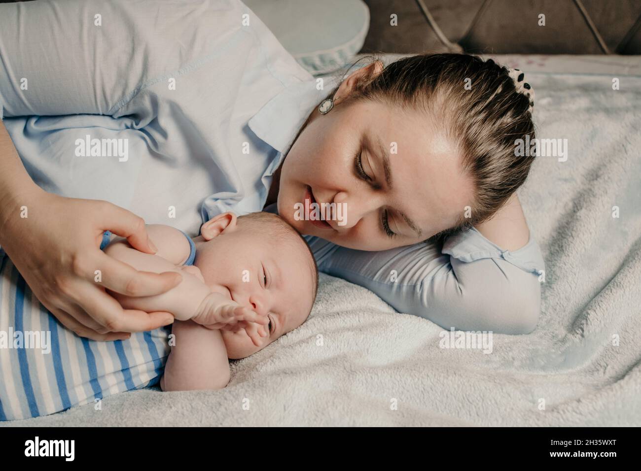Mother and newborn baby boy cuddling in bed Stock Photo - Alamy