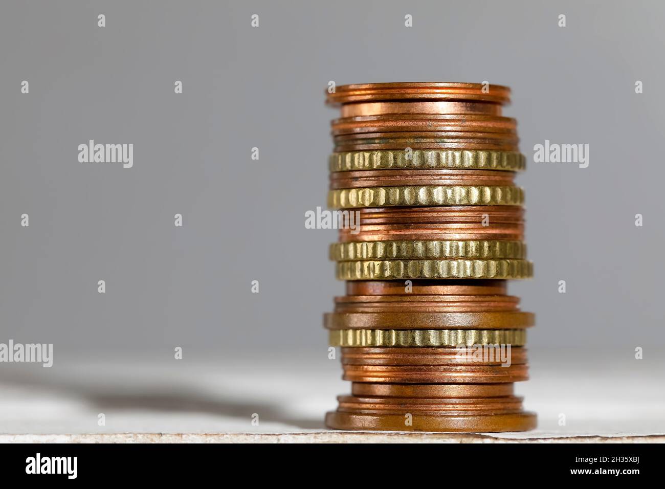 Various small euro coins of various colors have been stacked on top of ...