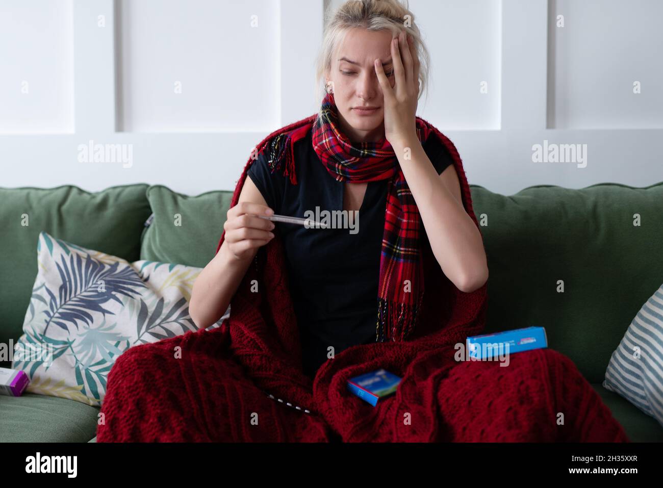 Woman saddened by looking at thermometer because of elevated body ...