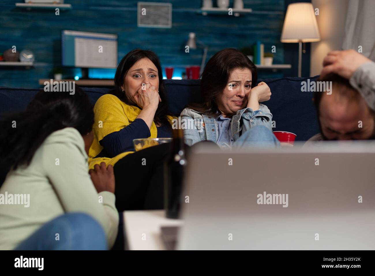 Terrified scared group of people watching horror scary movie on laptop ...
