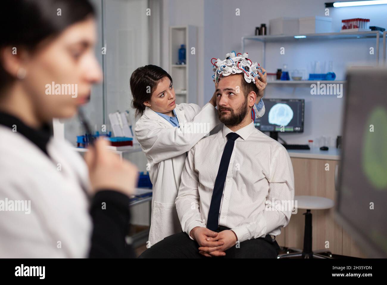 Specialist researcher woman putting eeg headset on man patient ...