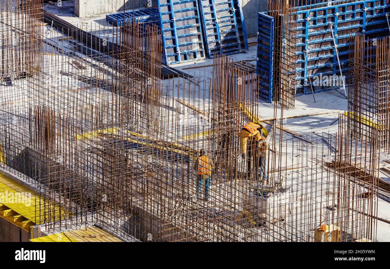 Construction workers install formwork and iron rebars or reinforcing ...