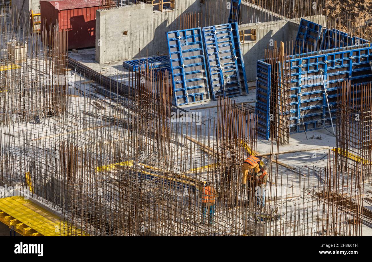 Construction workers install formwork and iron rebars or reinforcing ...