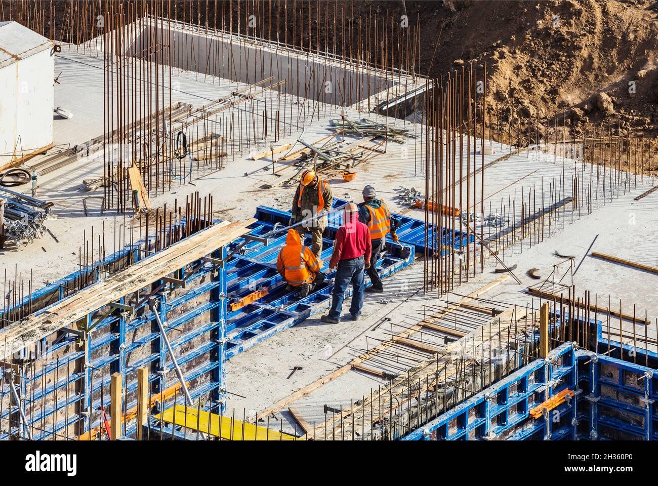 Construction workers install formwork and iron rebars or reinforcing ...