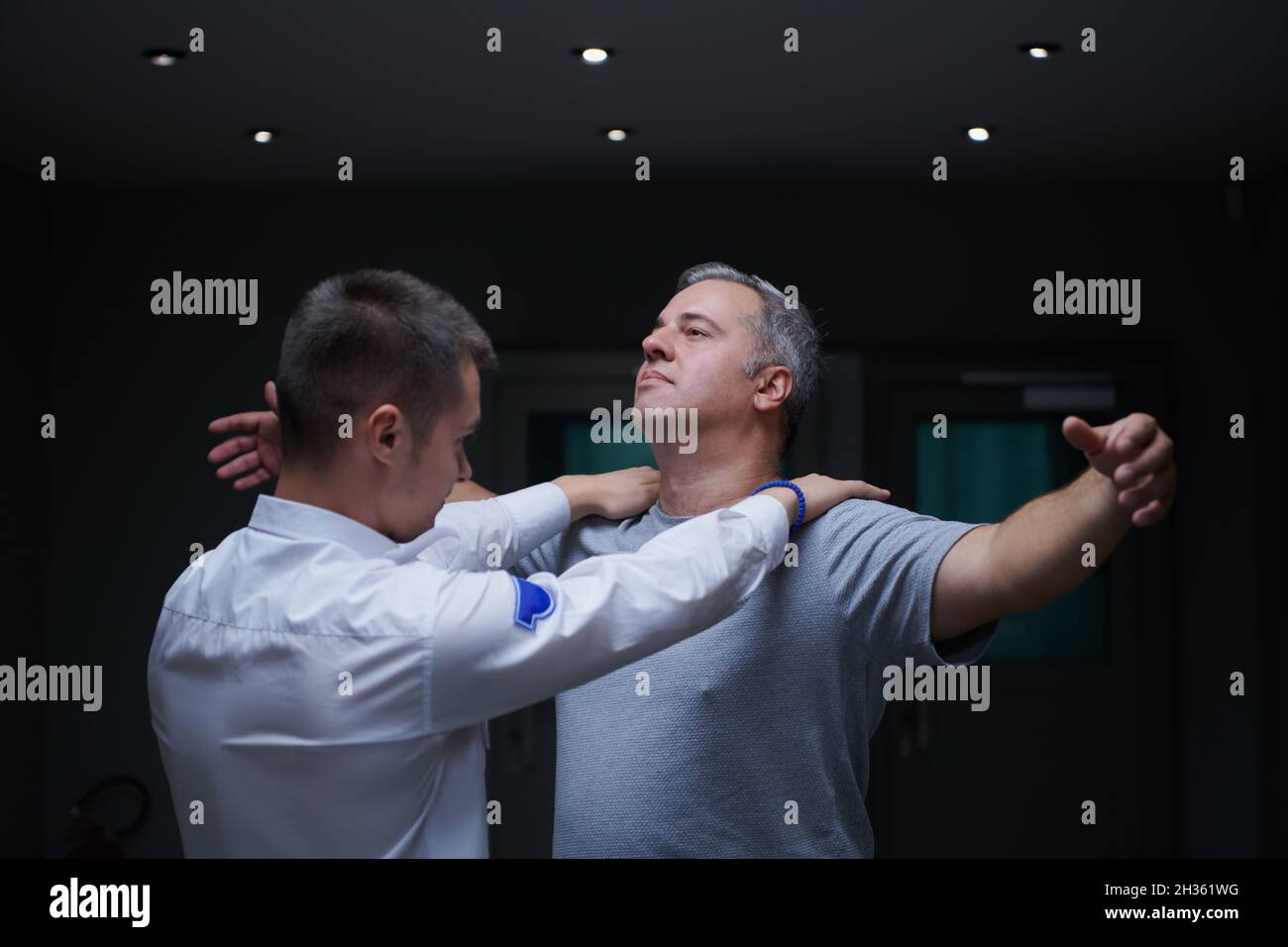 Security guard making body searching procedure on man for finding ...