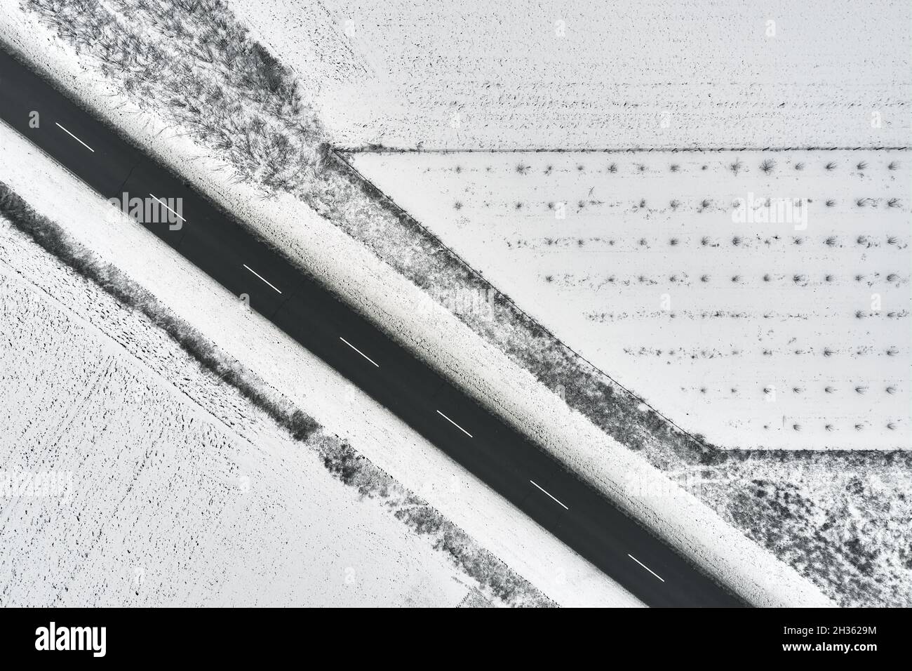 Top view aerial photo of empty road through countryside in winter ...