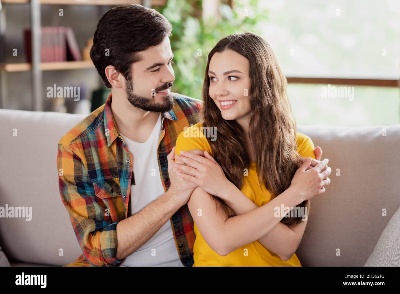 Photo of sweet tender young lovers dressed casual clothes sitting sofa ...