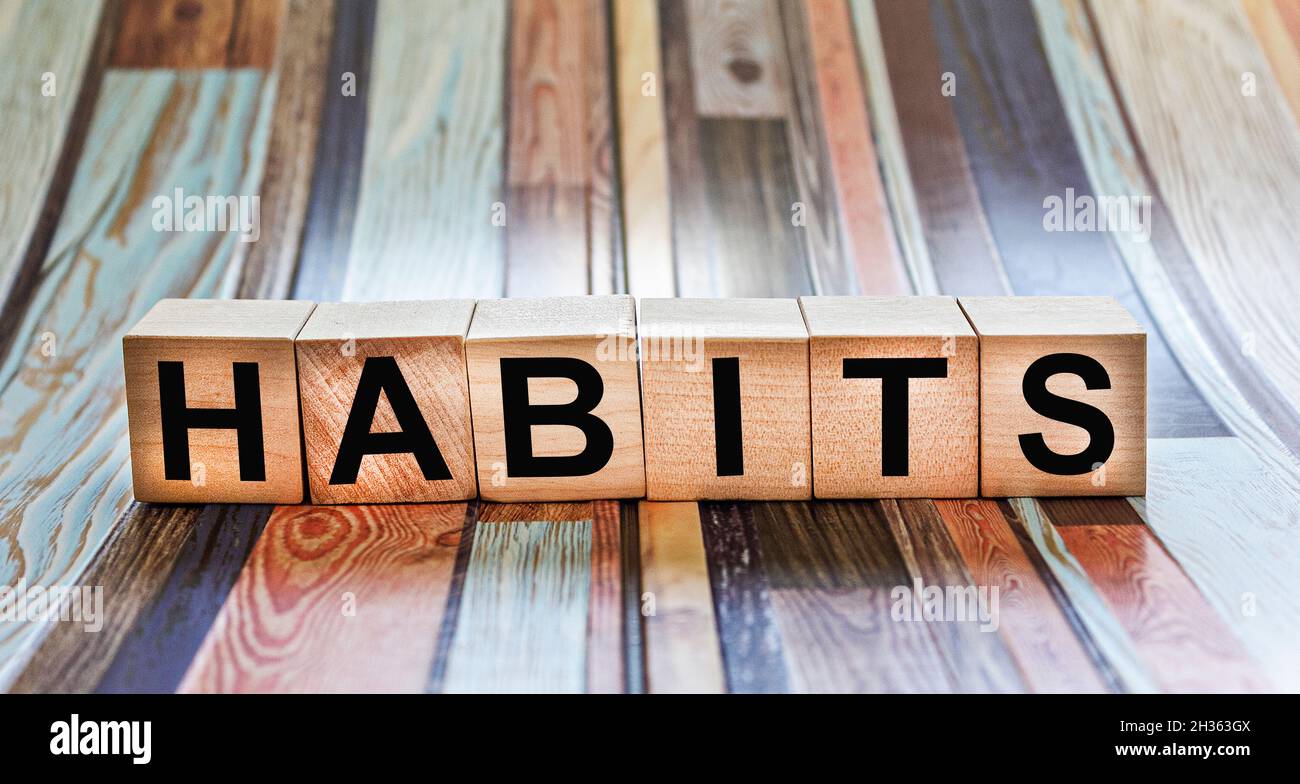 The word habits is written on wooden cubes that lie on a colored ...