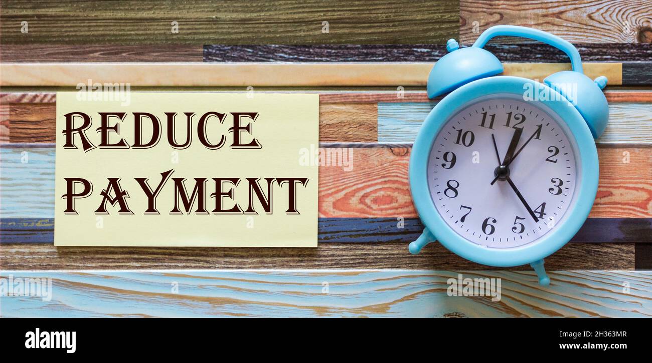 The words Reduce payment on a sticker, next to an alarm clock on a ...
