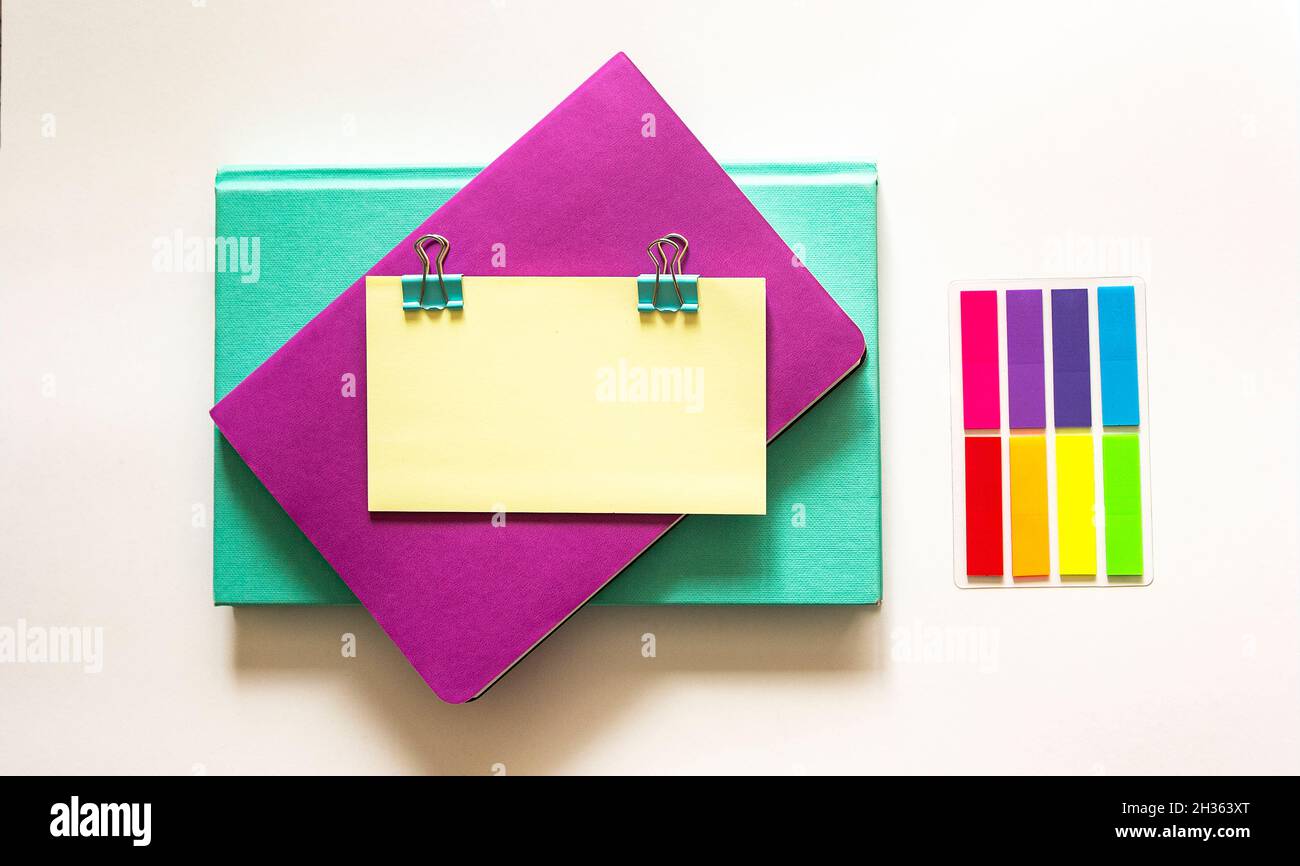 Two multi-colored notebook and color stickers on a white background ...