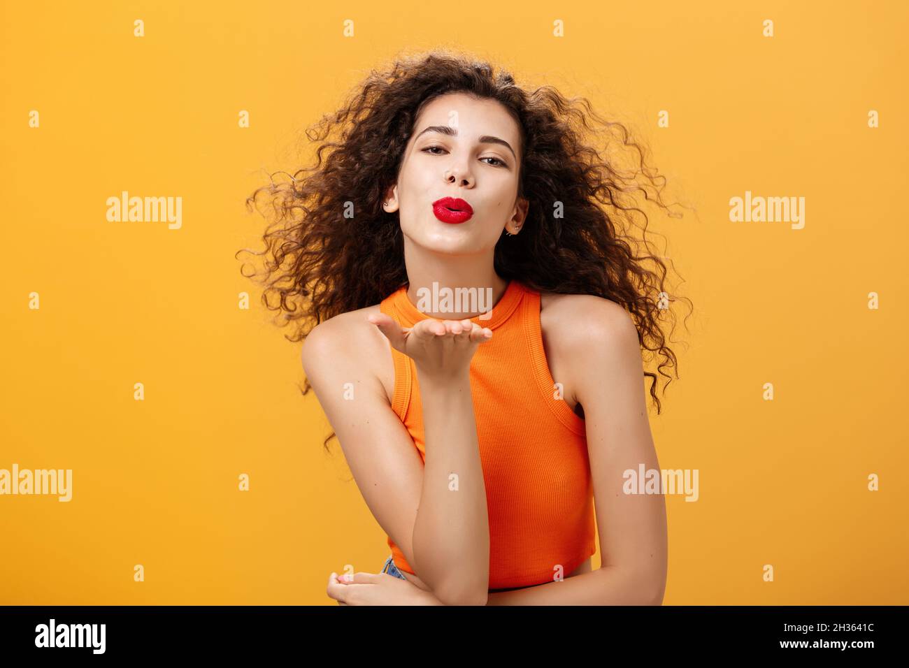 Flirty confident and sensual stylish woman with curly hairstyle and red ...