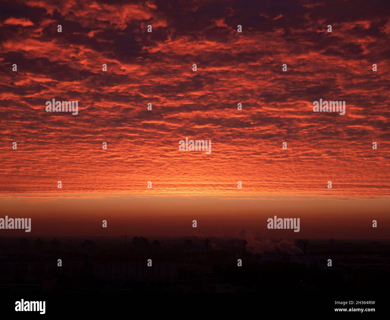 Red ominous clouds hovering above the ground at dawn. Red-tinted sky at ...