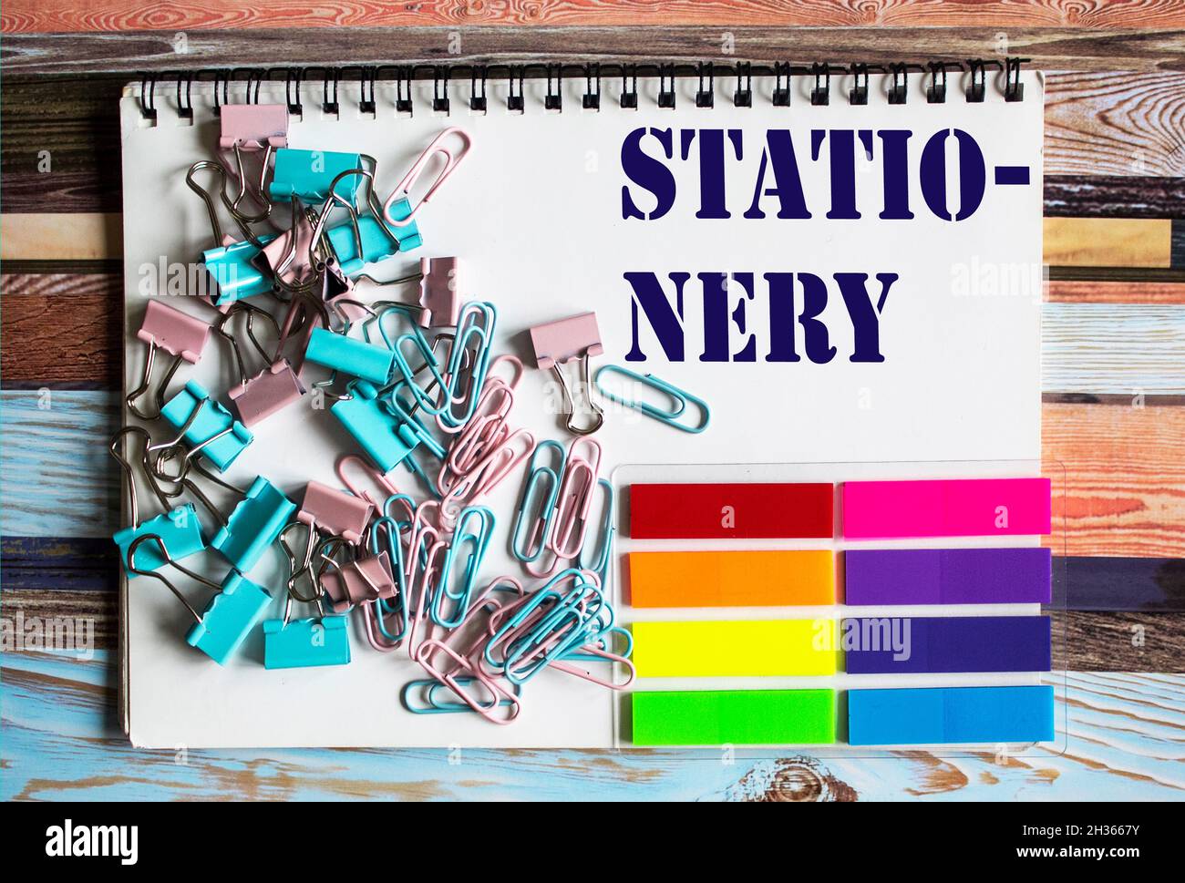 Colorful paper clips and stickers on a wooden background and with the ...