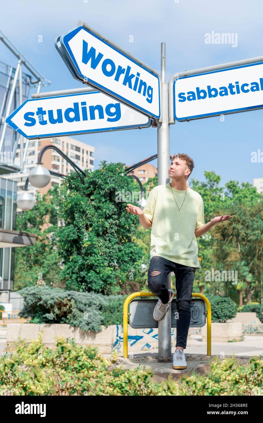 Undecided young man gesturing with open arms not knowing which option ...