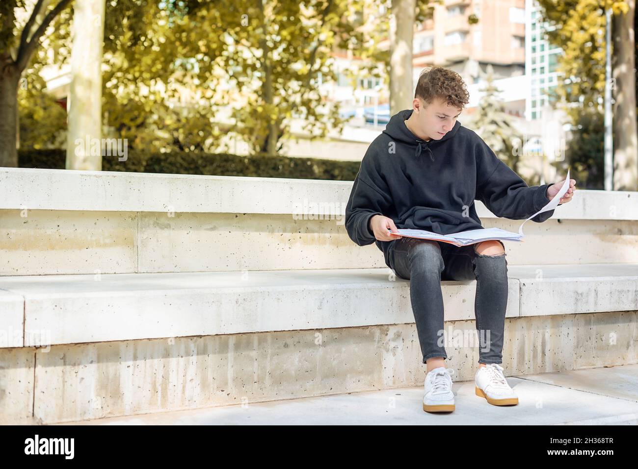 Young student boy looking at his notes at university Stock Photo - Alamy