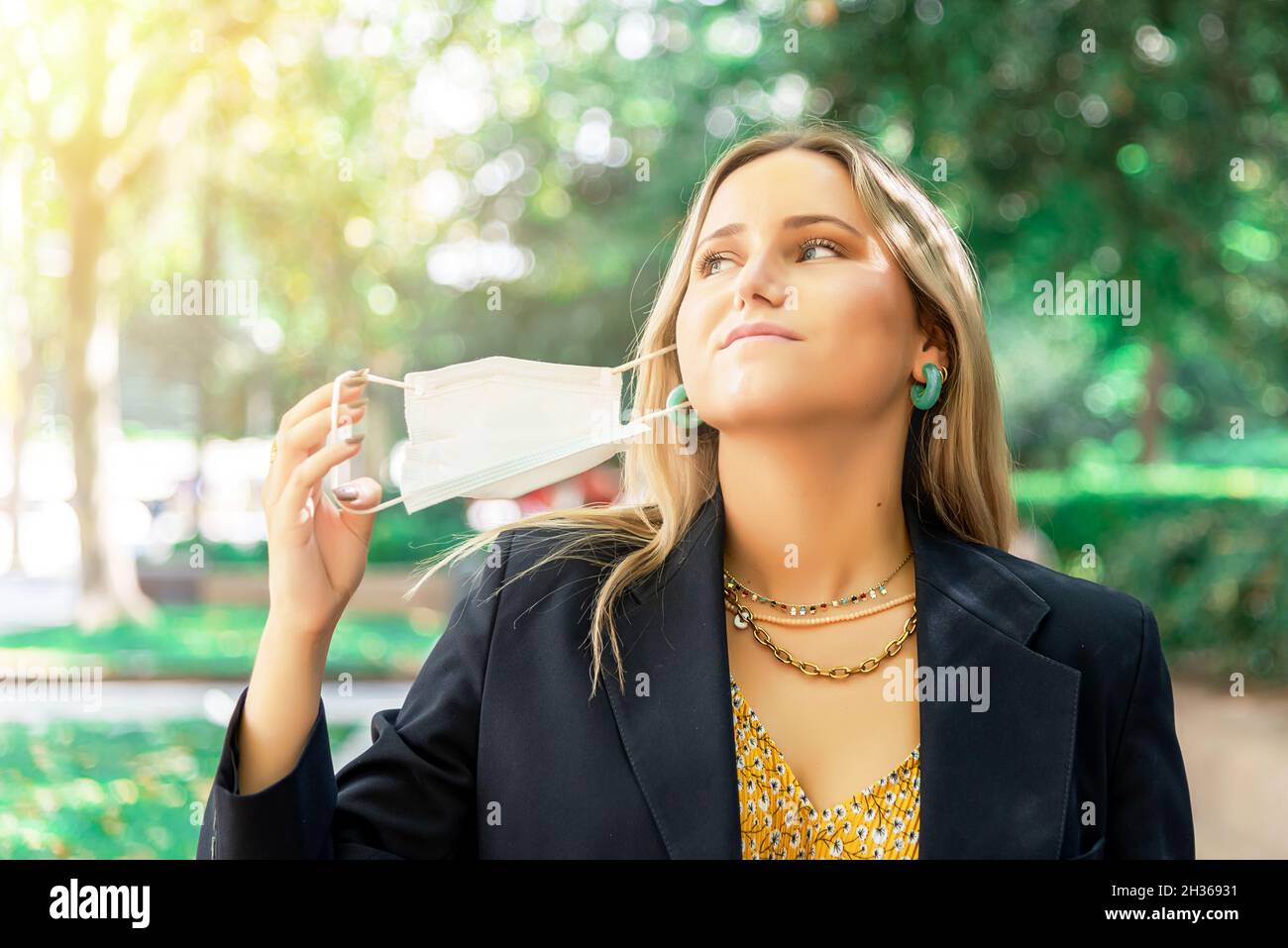 Beautiful blonde woman taking off a mask and feeling relieved to ...