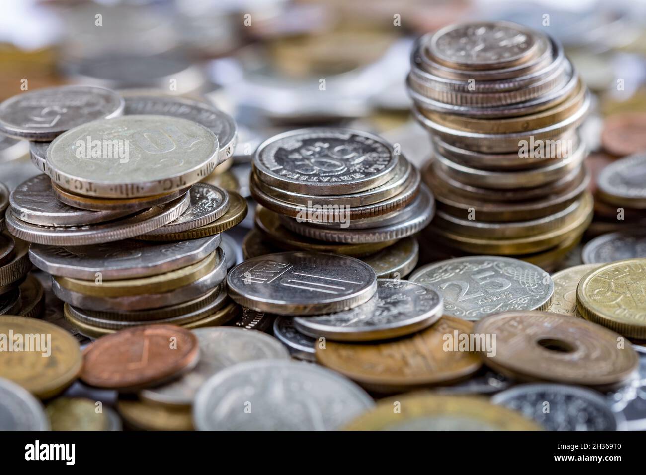 Various multi-colored coins of the currency of the whole world stacked ...