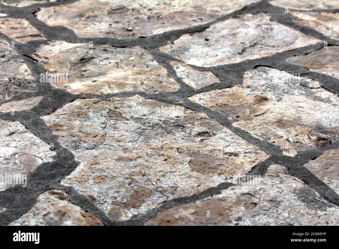 Traditional natural stone tiles sidewalk made from various size rocks ...