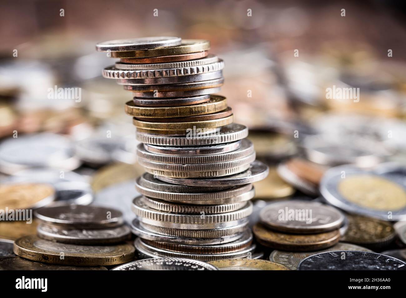 Various multi-colored coins of the currency of the whole world stacked ...