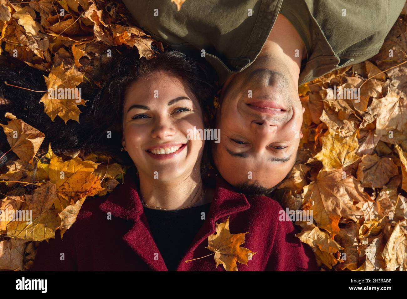 Top view of couple laying in autumn leaves. Love and happiness concept ...