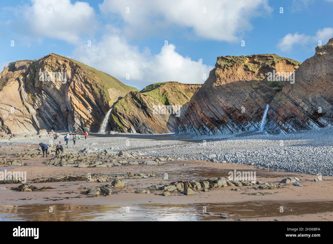 People on the beach near the waterfalls at Sandymouth near Bude Devon ...