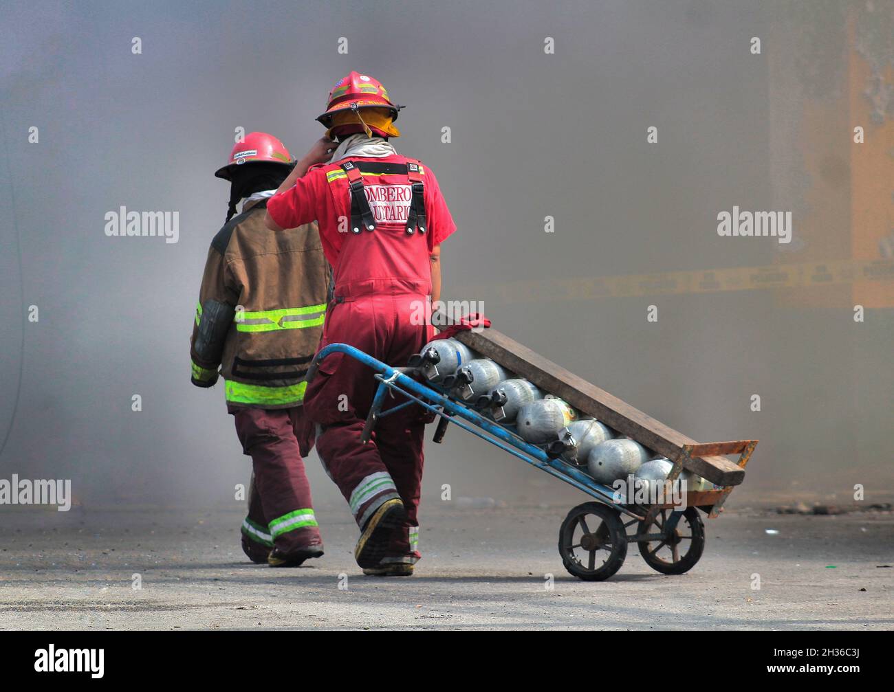Closeup of two firefighters bringing oxygen tanks during an emergency ...