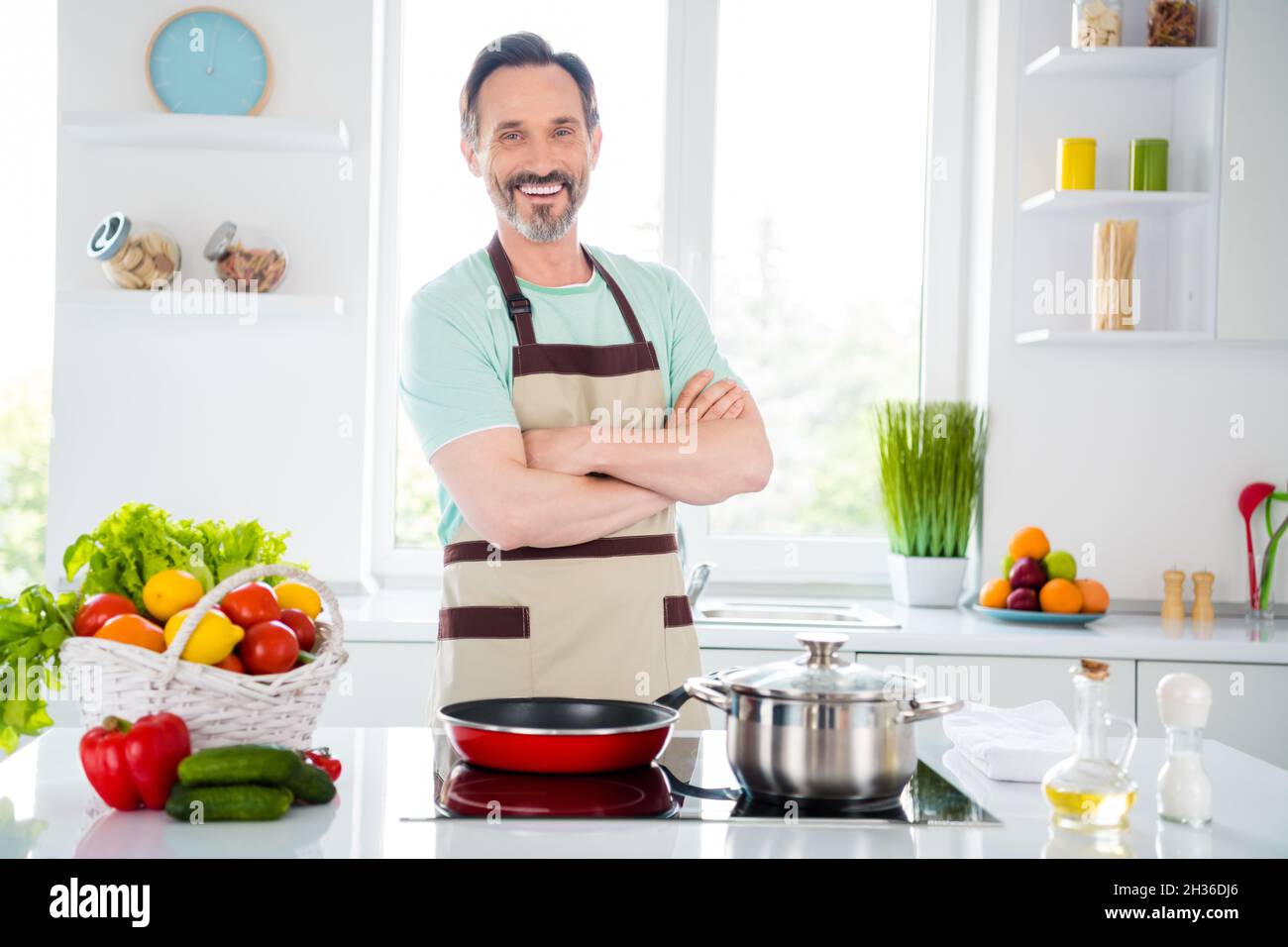 Photo of charming confident mature guy wear blue t-shirt apron cooking ...