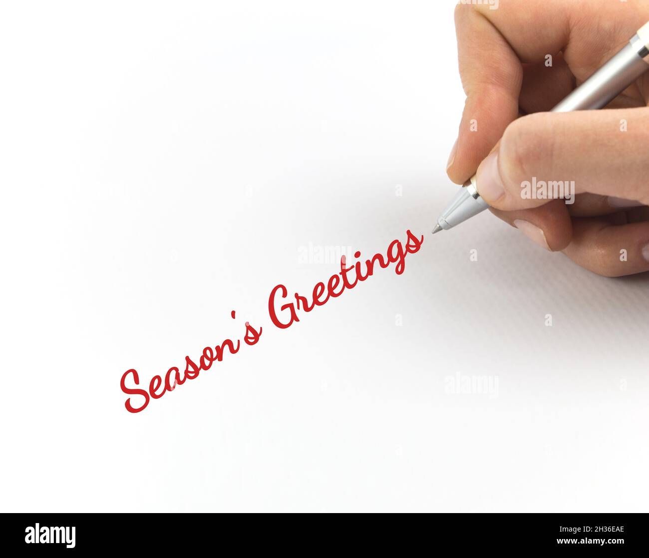 Hand writing "Season's Greetings" on white sheet of paper Stock Photo ...