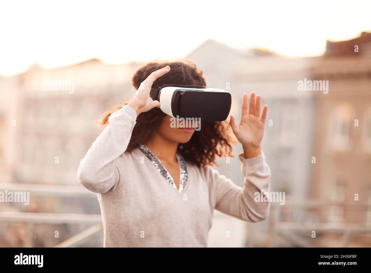 Future technology. Young modern mixed-race woman in VR goggles headset ...