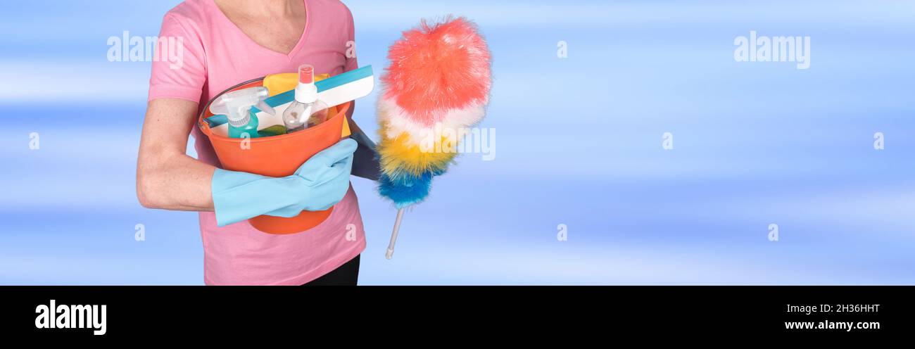 Housewife holding a duster and a bucket with cleaning equipment on ...