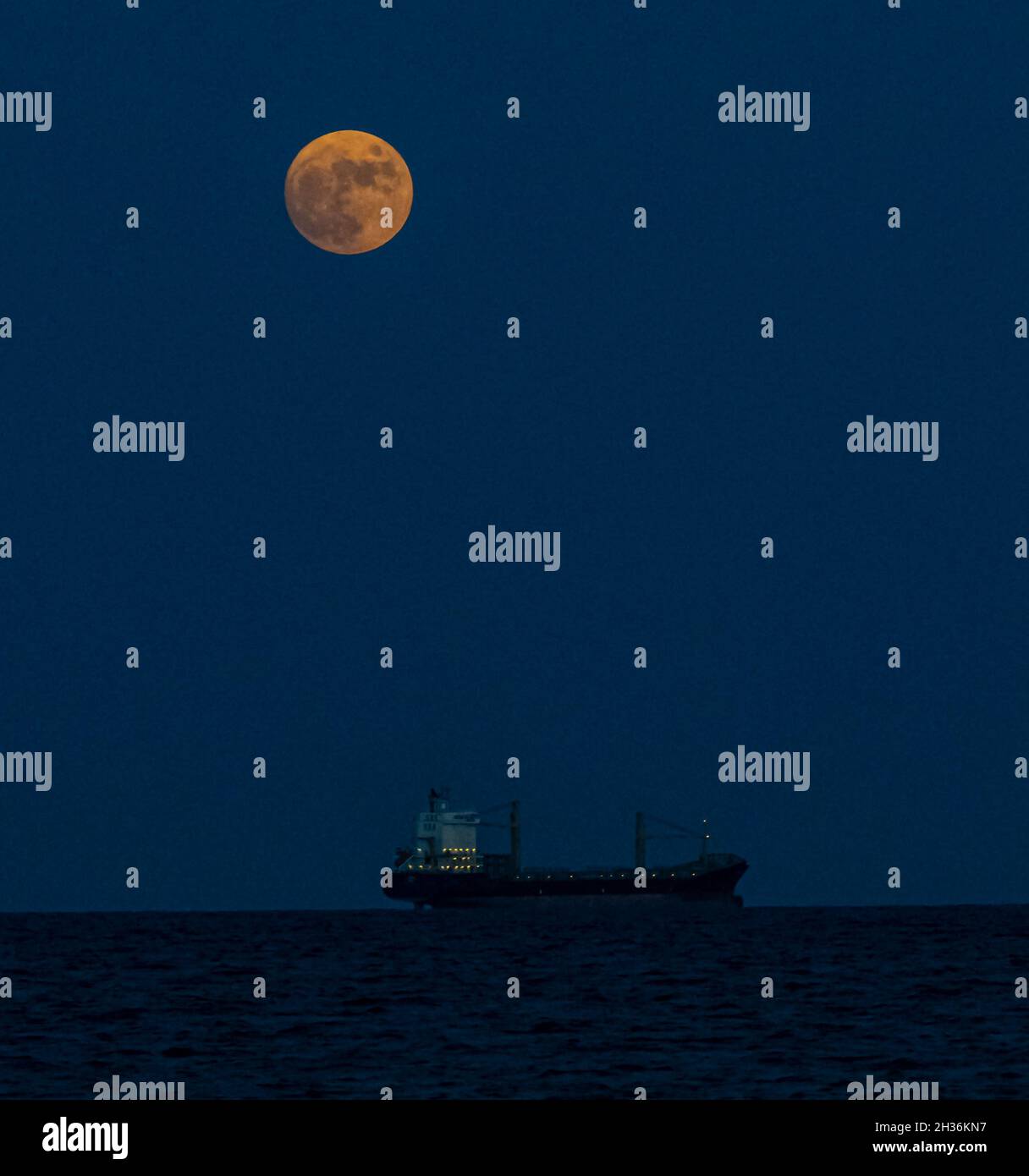 Ship on the Atlantic Ocean with the full moon in the sky in the evening ...