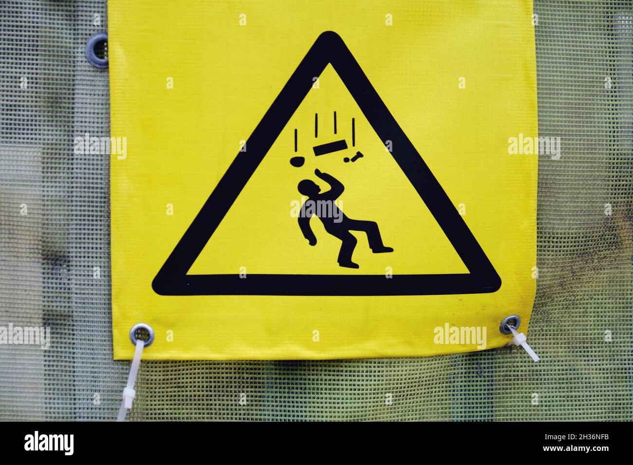 A sign of falling objects, debris and bricks on the fence near the ...