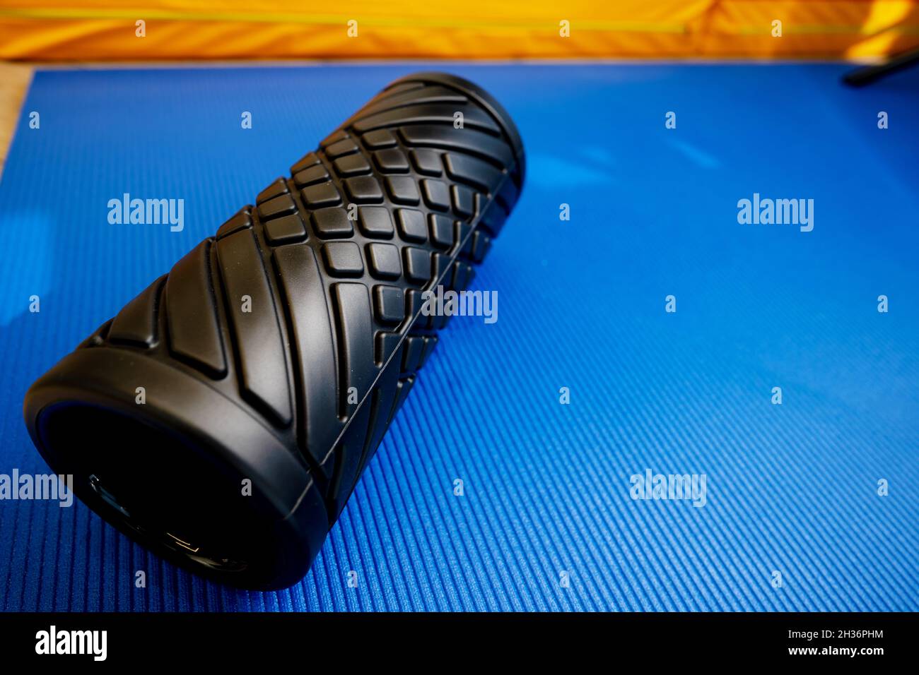 Sport fitness foam roller on blue mat Stock Photo - Alamy