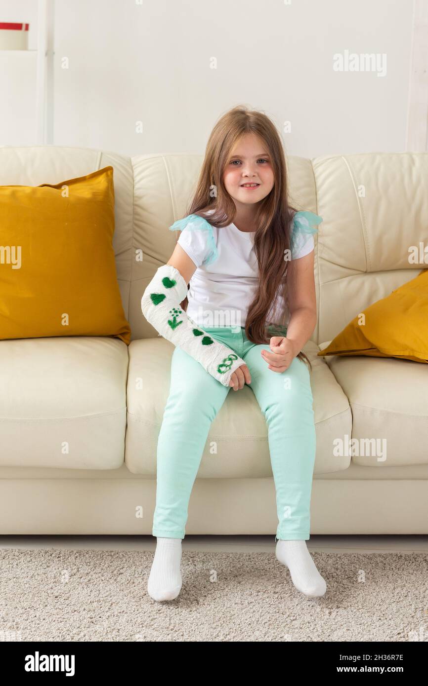 Child with a cast on a broken wrist or arm smiling and having fun on a ...