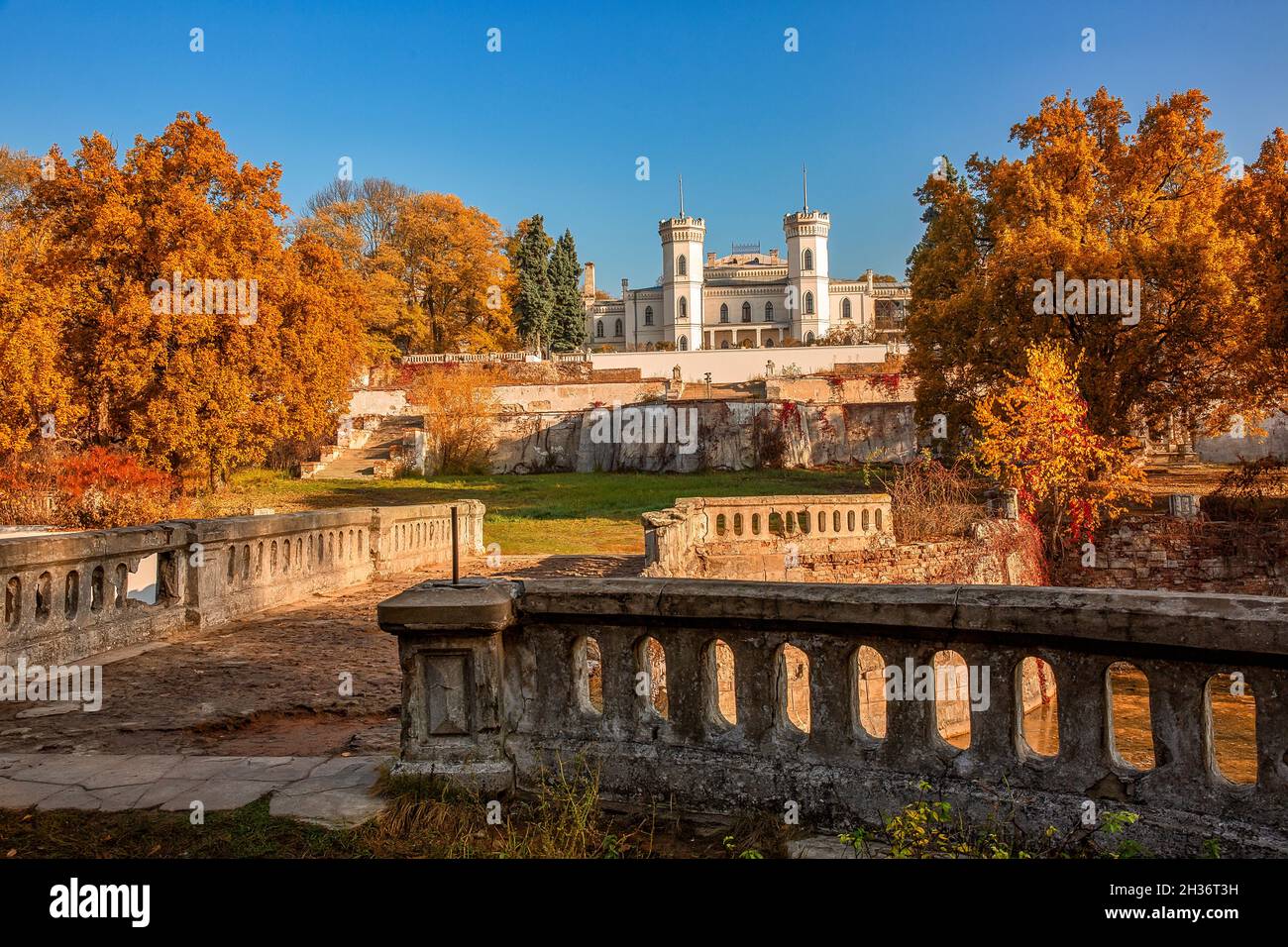 Beautiful old white castle surrounded by landscape park, fall season ...