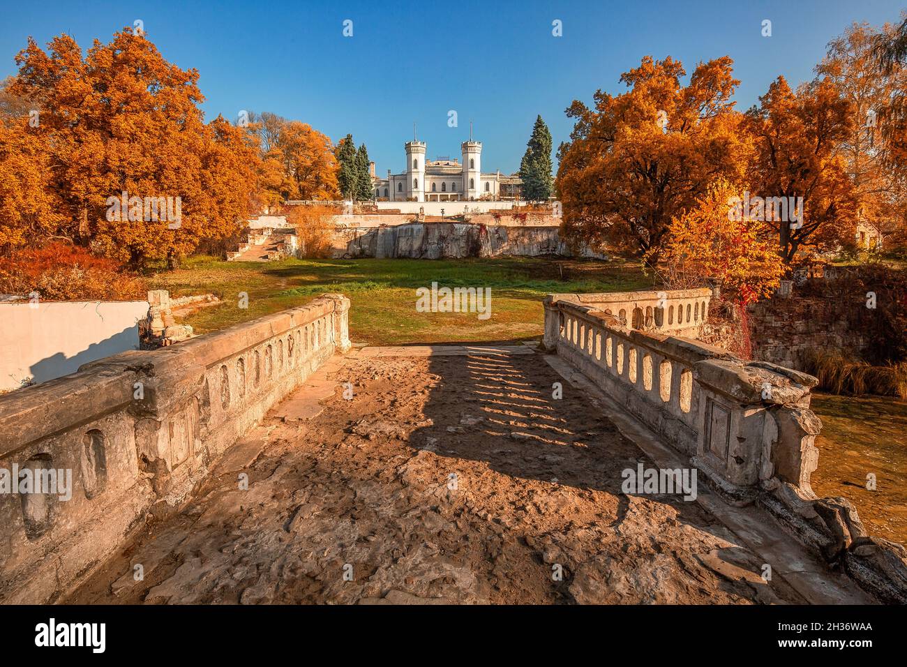 Beautiful old white castle surrounded by landscape park, fall season ...