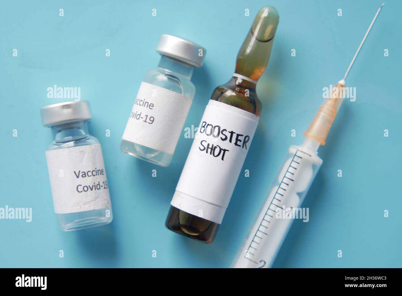 booster shot dose coronavirus vaccine and syringe on blue Stock Photo ...