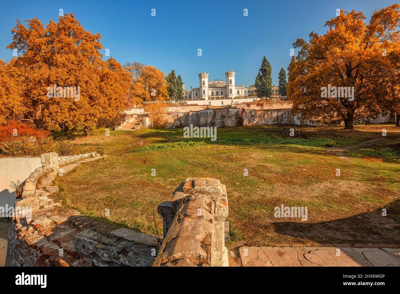 Beautiful old white castle surrounded by landscape park, fall season ...