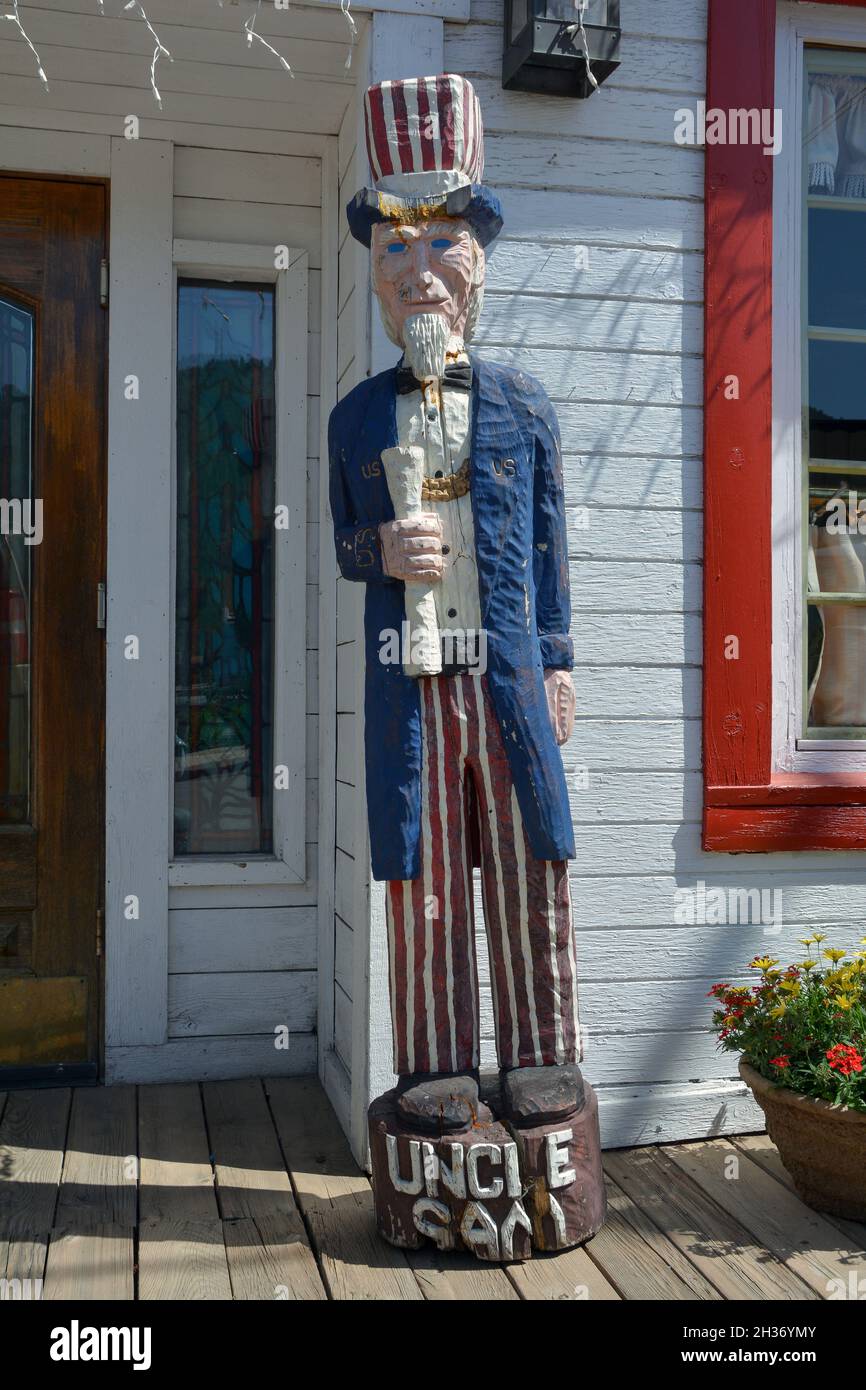 A larger than life sized wooden sculpture of Uncle Sam outside a shop ...