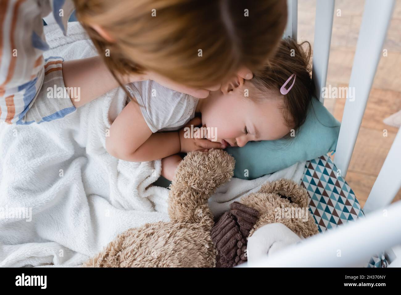 Overhead view of parent touching daughter with down syndrome in baby ...