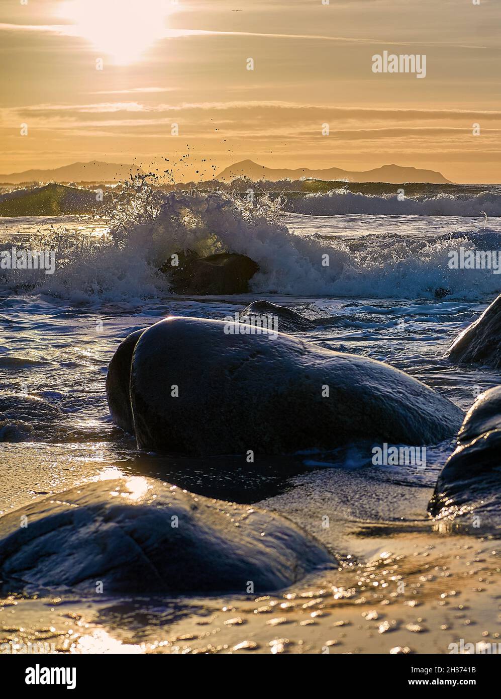 Rock catching a wave on Alnes beach, Godøy, Norway Stock Photo - Alamy