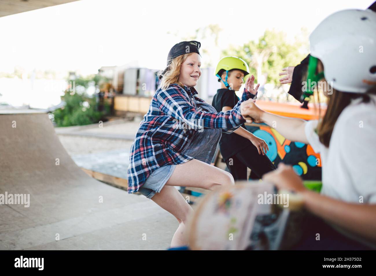 Boys girls friends have fun together howling during skateboarding ...