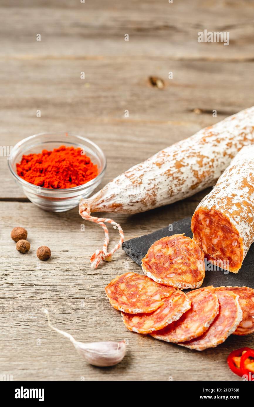 Sliced Chorizo Sausage on a wooden background with smoked paprika ...