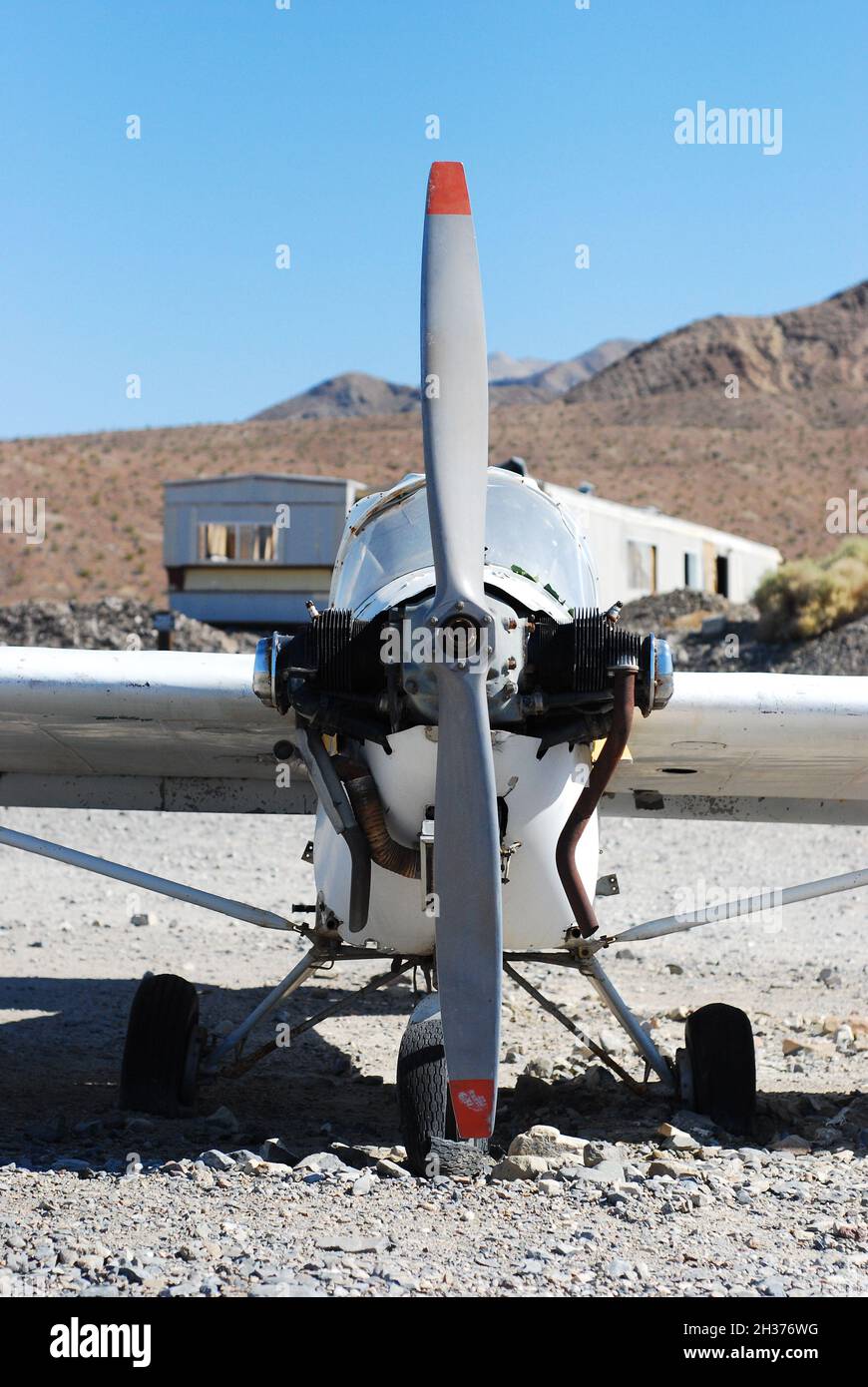 Vertical shot of a white propeller airplane in the Death Valley in ...