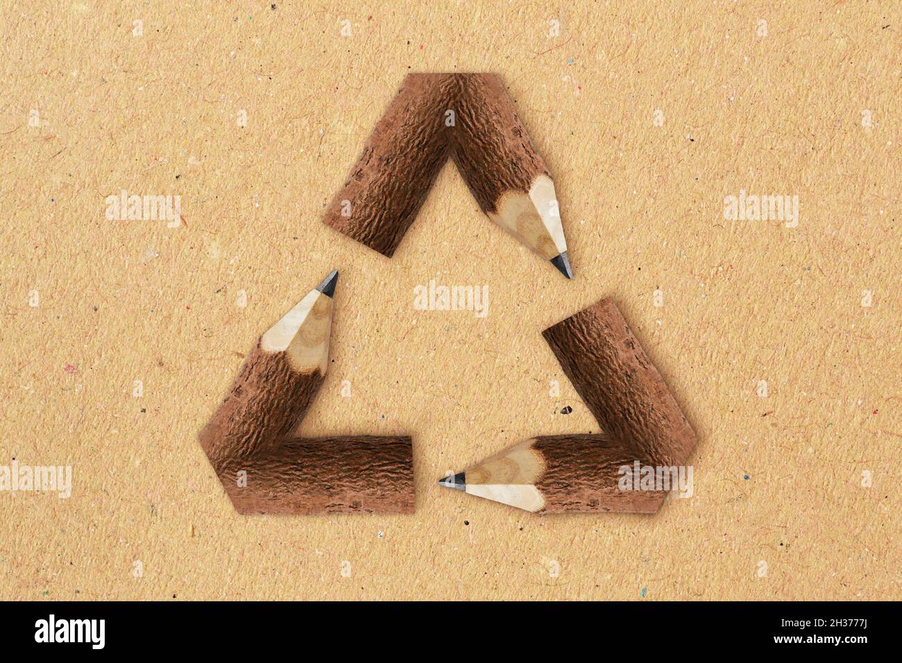 Recycling symbol made of wooden pencils on recycled paper background ...