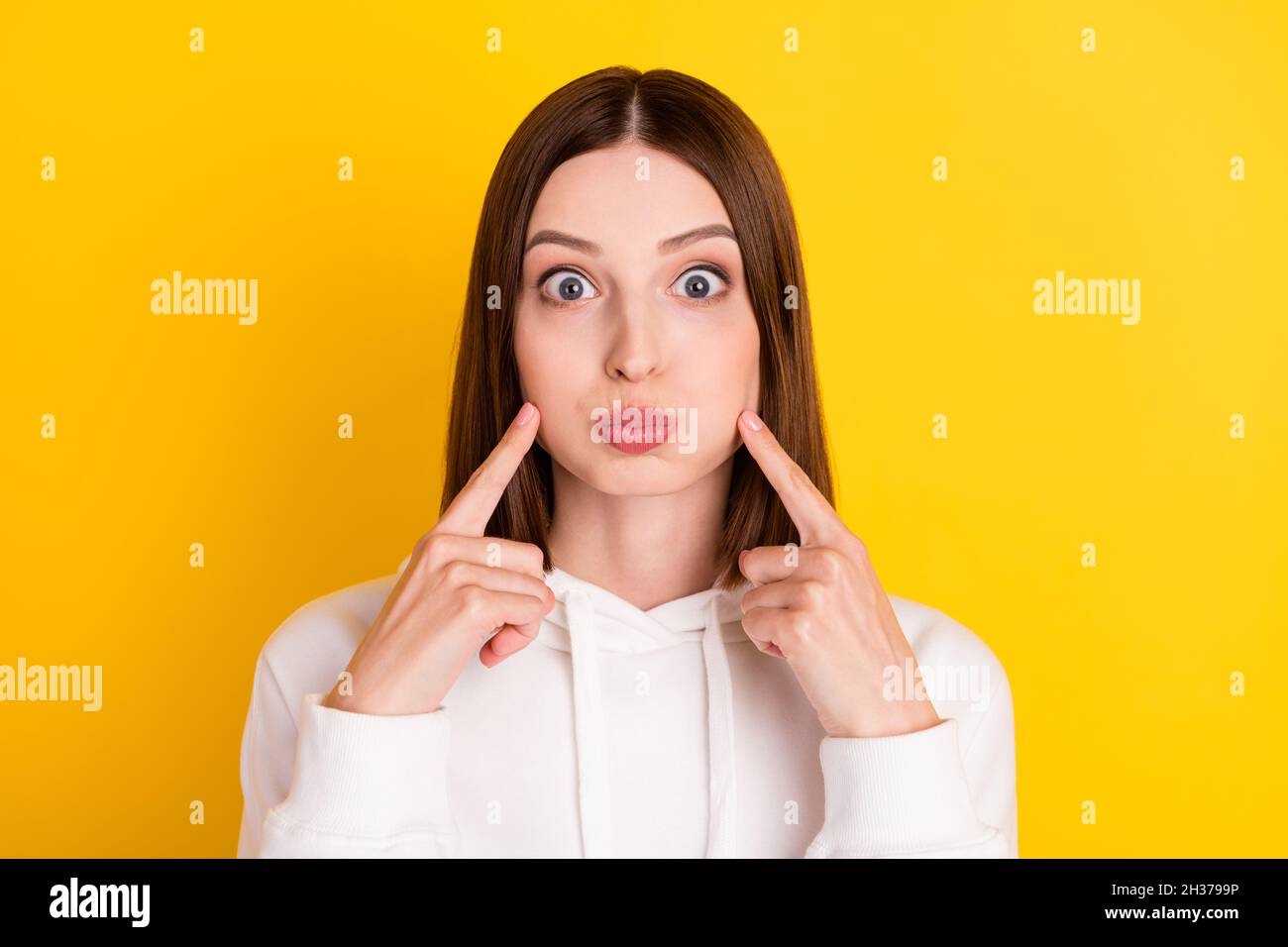 Photo of funny cute lady inflate cheeks press fingers wear white hoodie ...