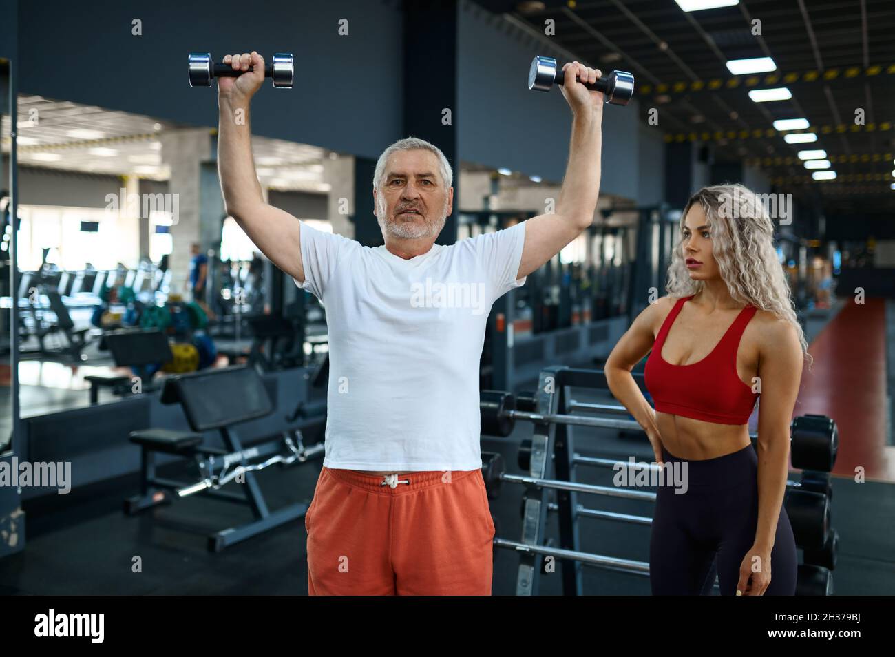 Old man, exercise with dumbbells, female trainer Stock Photo - Alamy