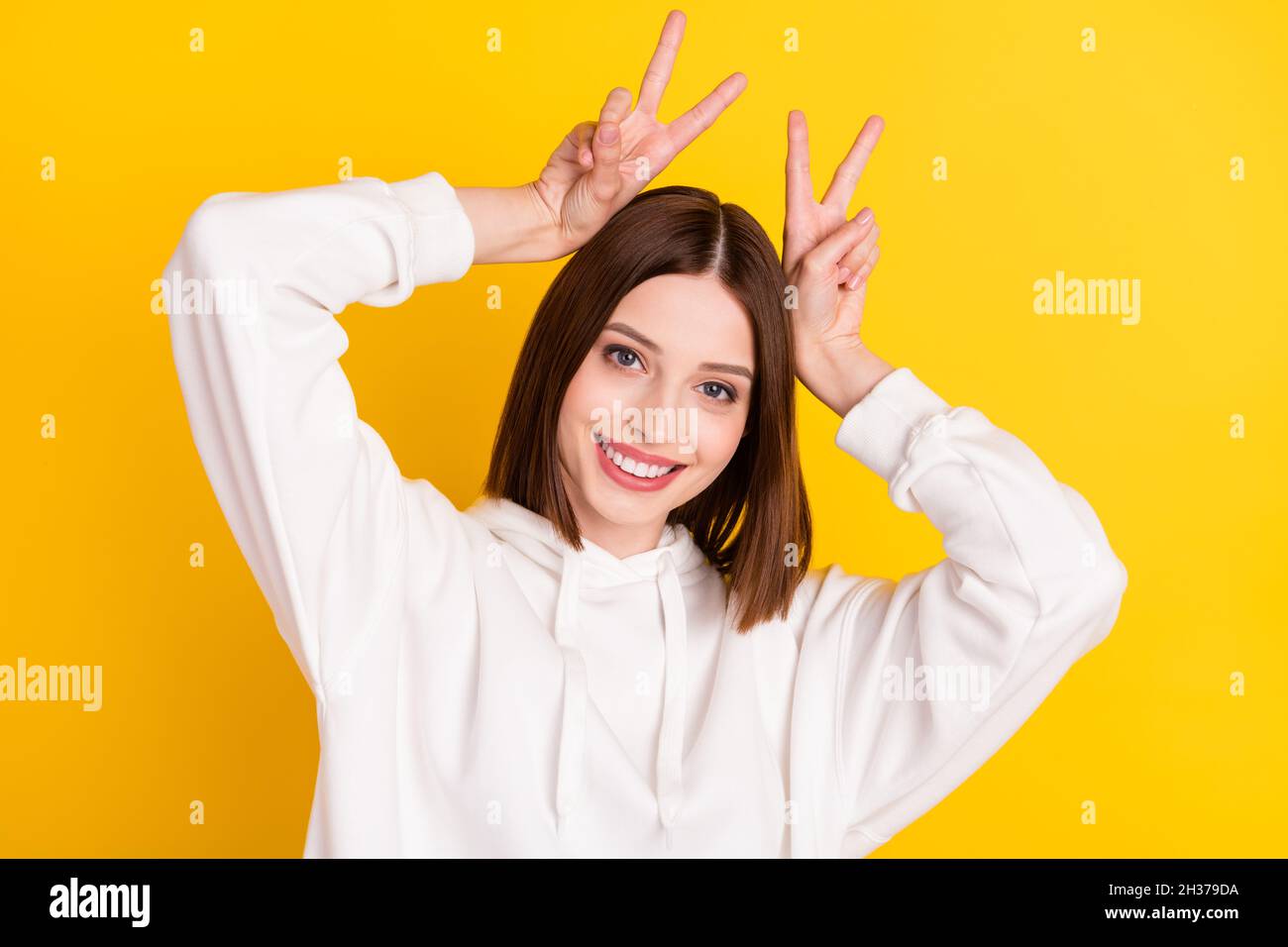 Portrait of attractive cheerful girl showing v-sign like ears having ...