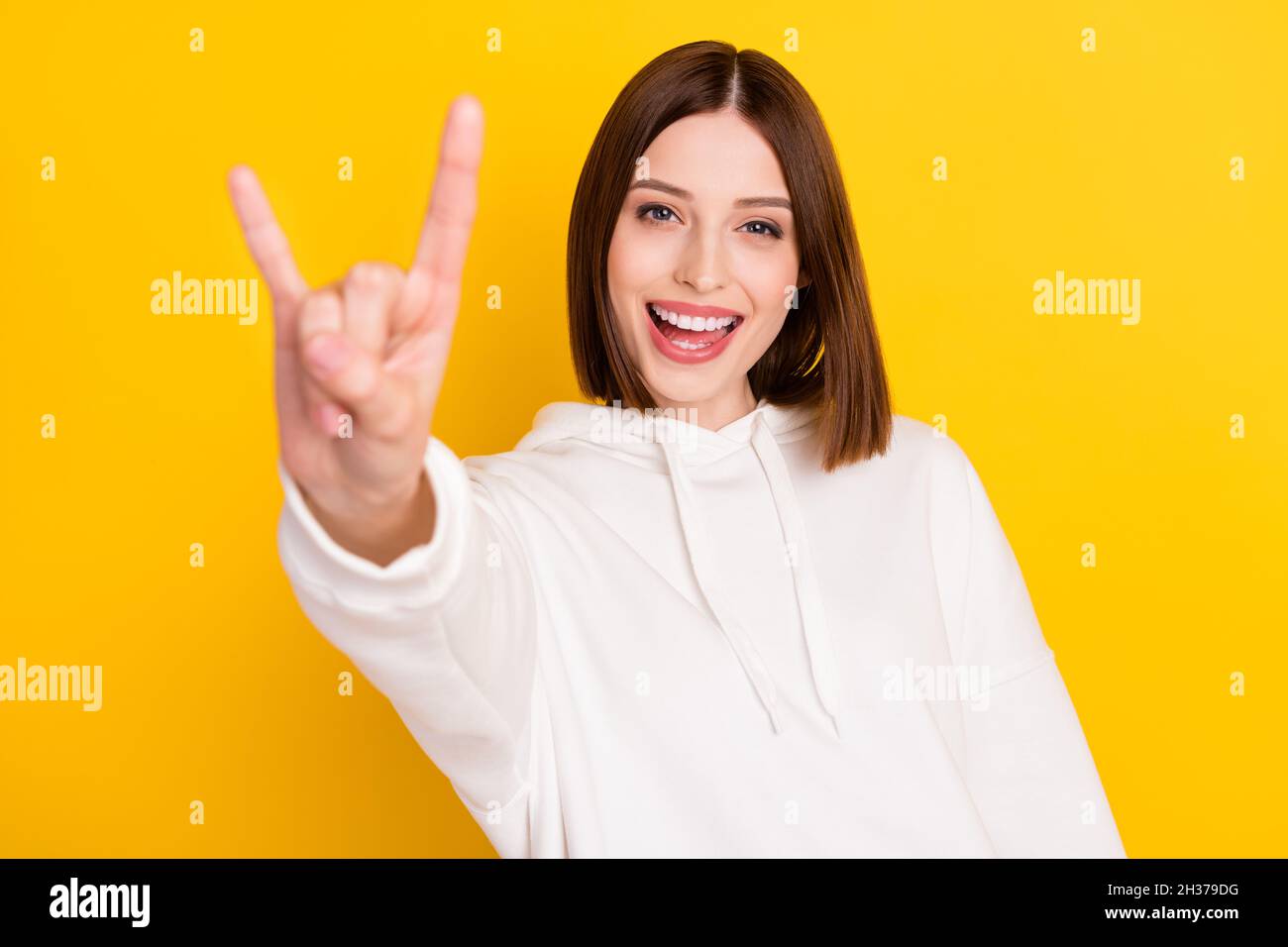 Photo of crazy harsh positive lady show horns gesture wear white ...