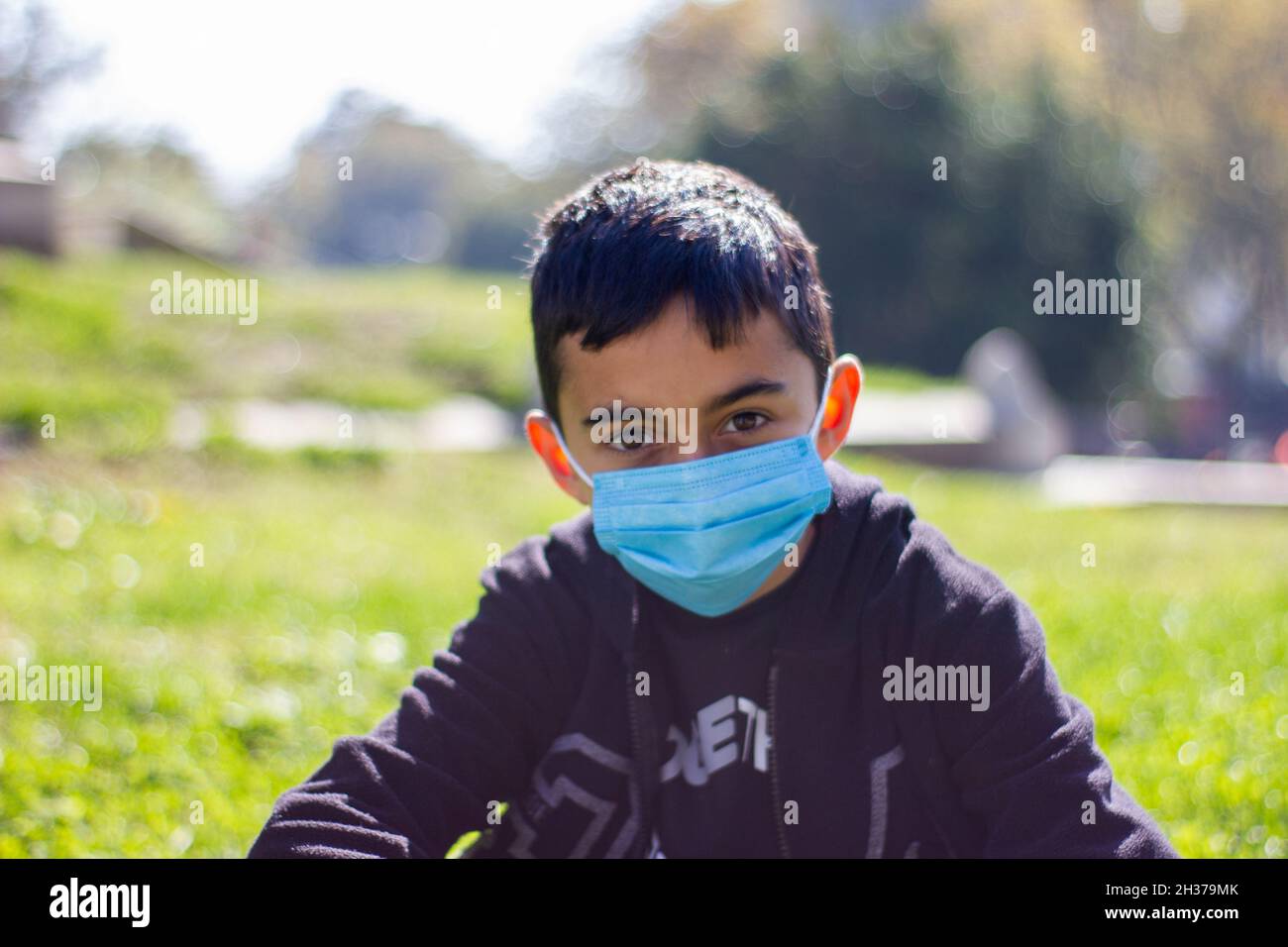 Concept of happy boy wearing face mask. Brunette boy in black shirt and ...
